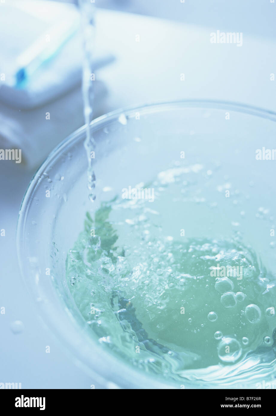 Running water and glass wash bowl Stock Photo - Alamy