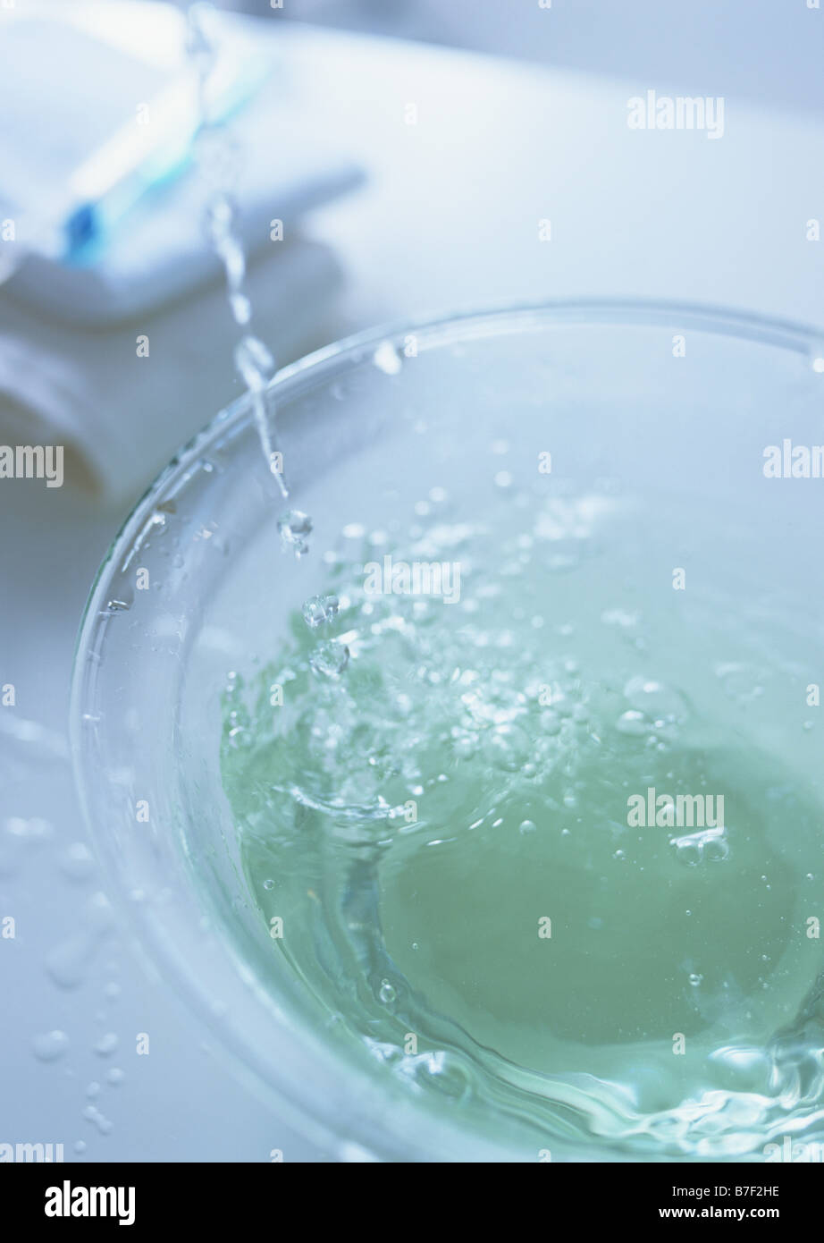Running water and glass wash bowl Stock Photo - Alamy