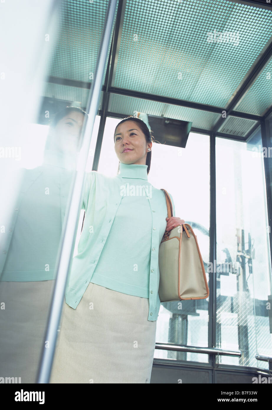 Business woman taking elevator Stock Photo - Alamy