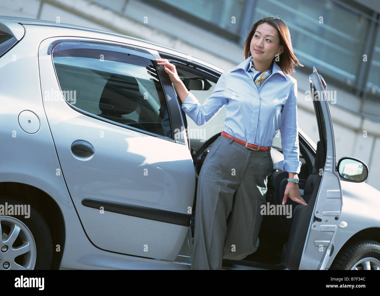 Business woman getting off a car Stock Photo - Alamy