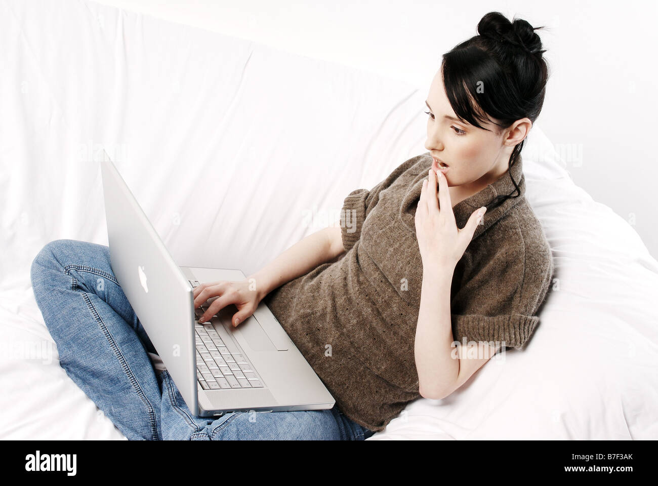 Young woman sitting on a sofa using a laptop computer Stock Photo - Alamy
