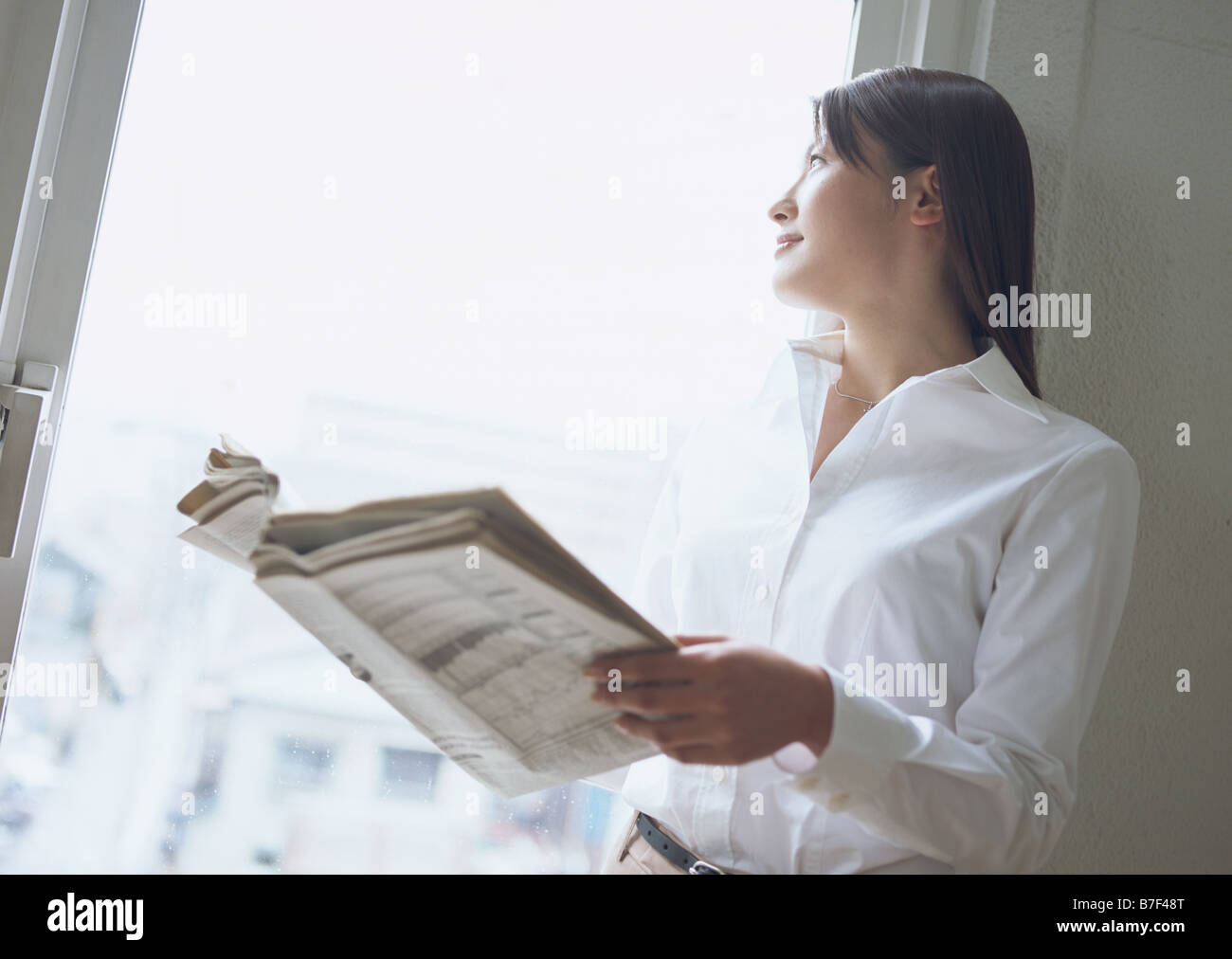 Business woman by window Stock Photo - Alamy