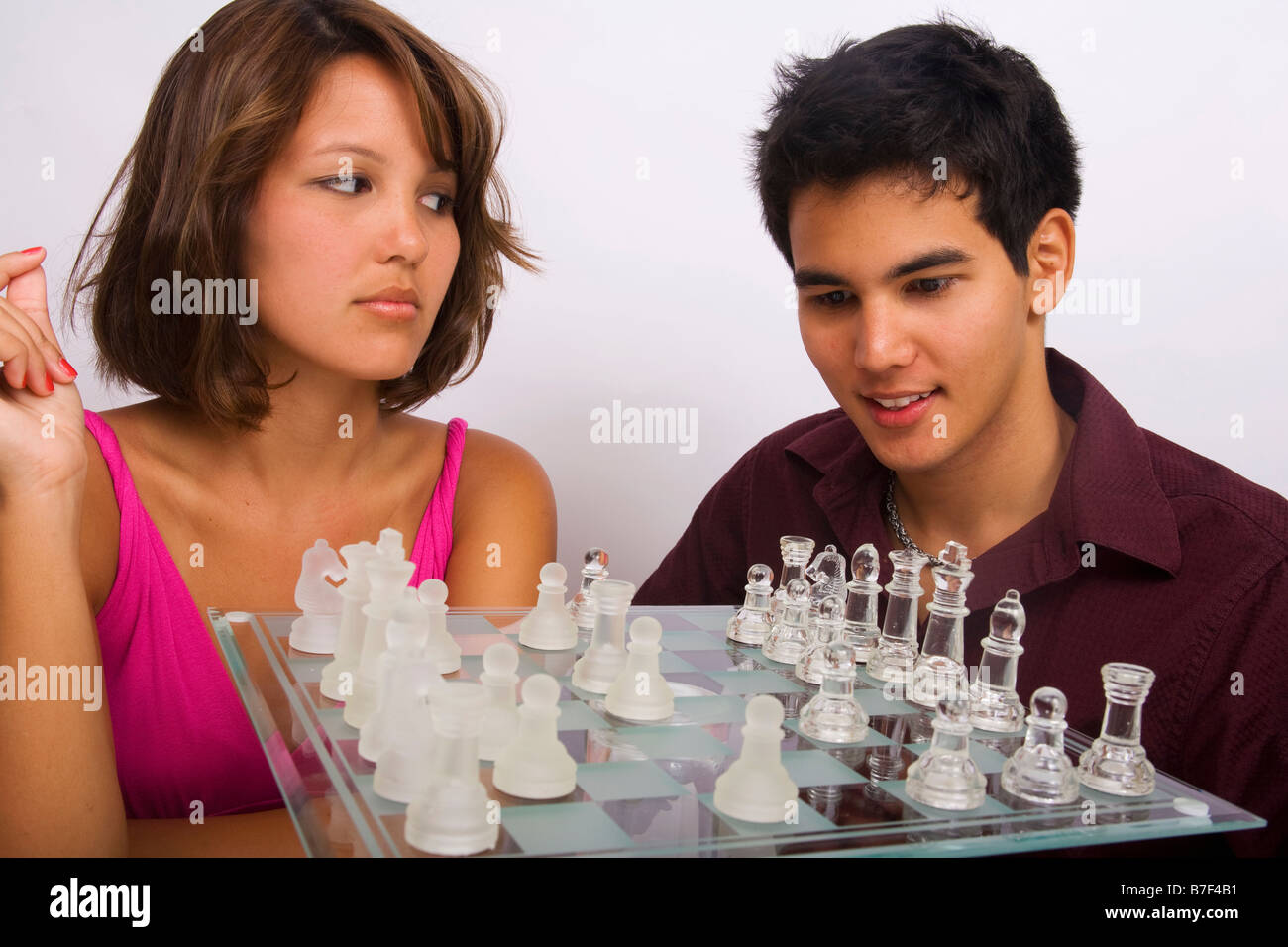 Two Asian American siblings playing a game of chess Stock Photo - Alamy