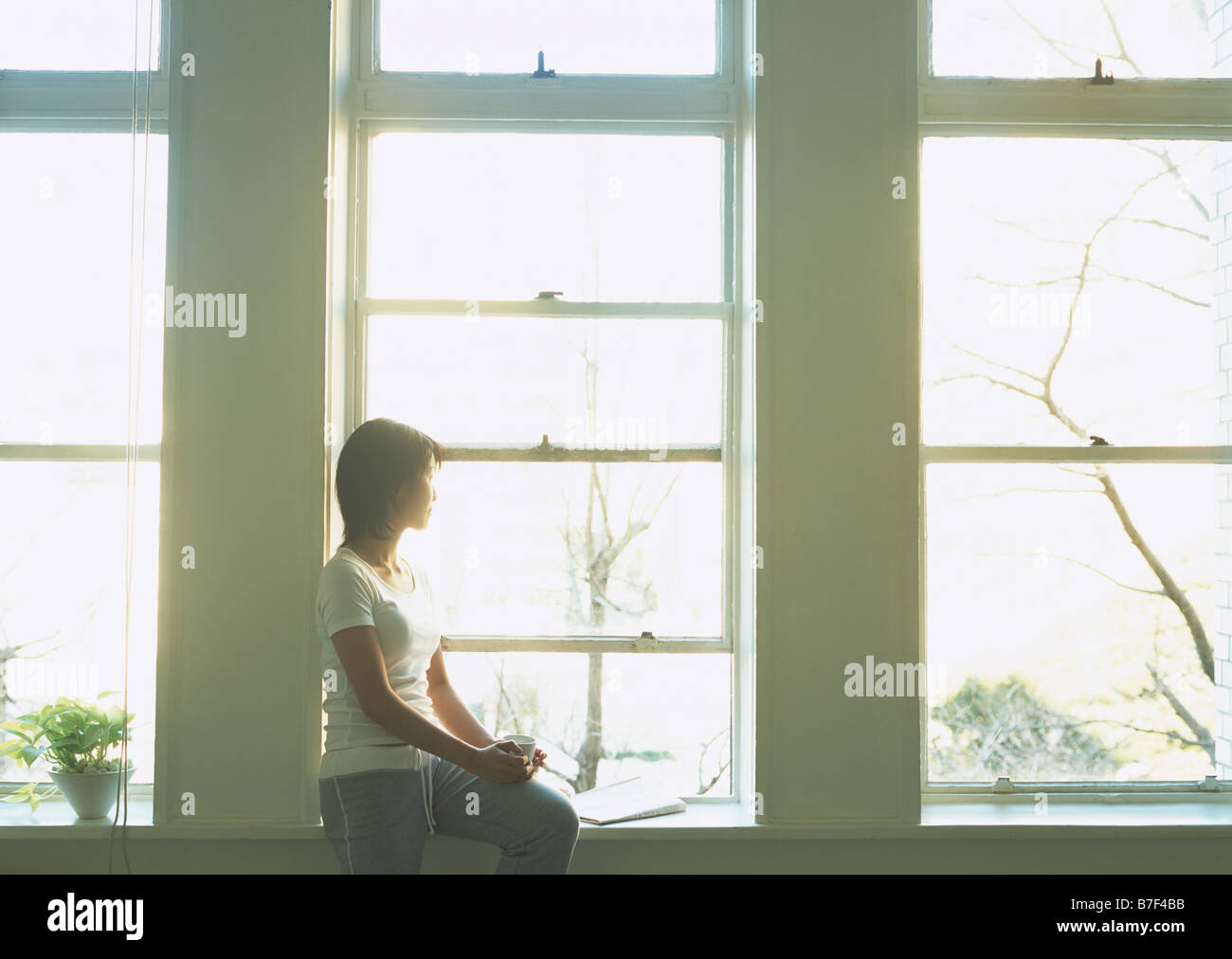 Woman by window Stock Photo - Alamy