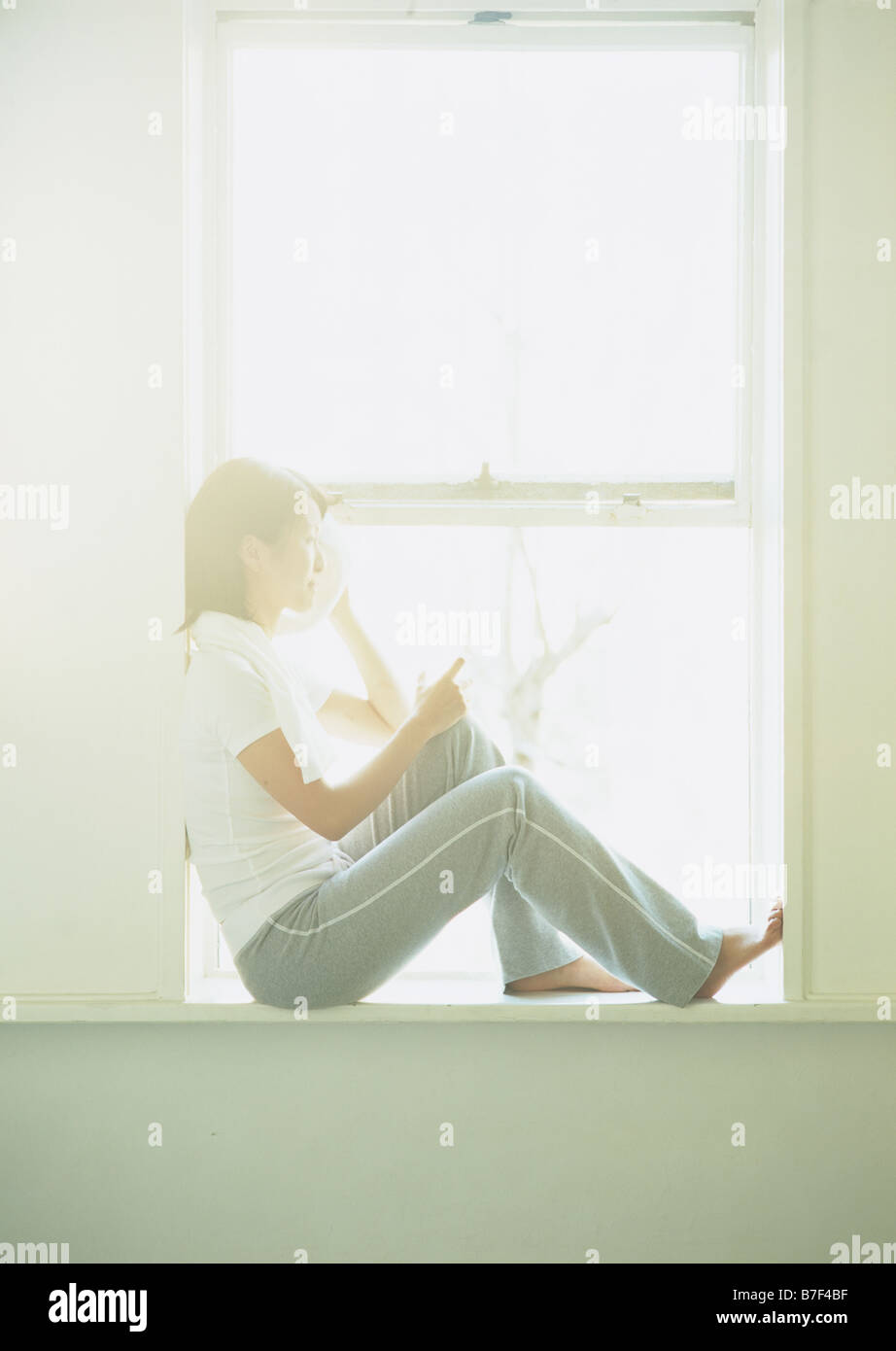 Woman by window Stock Photo - Alamy