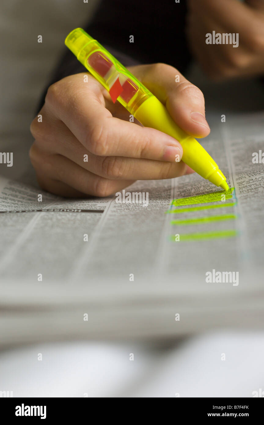 A person highlighting in a newspaper Stock Photo - Alamy