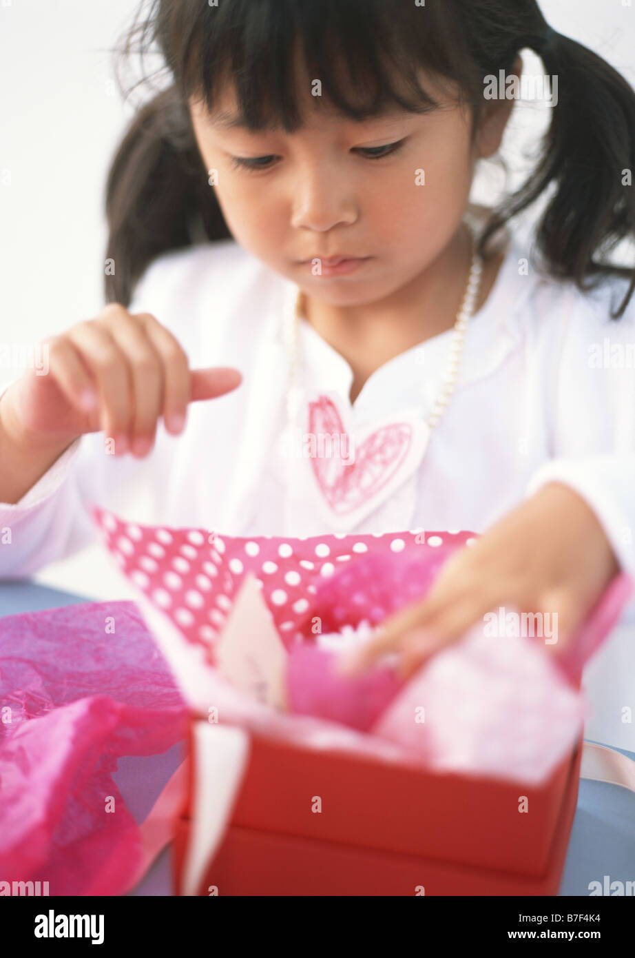 Girl opening red gift box Stock Photo - Alamy