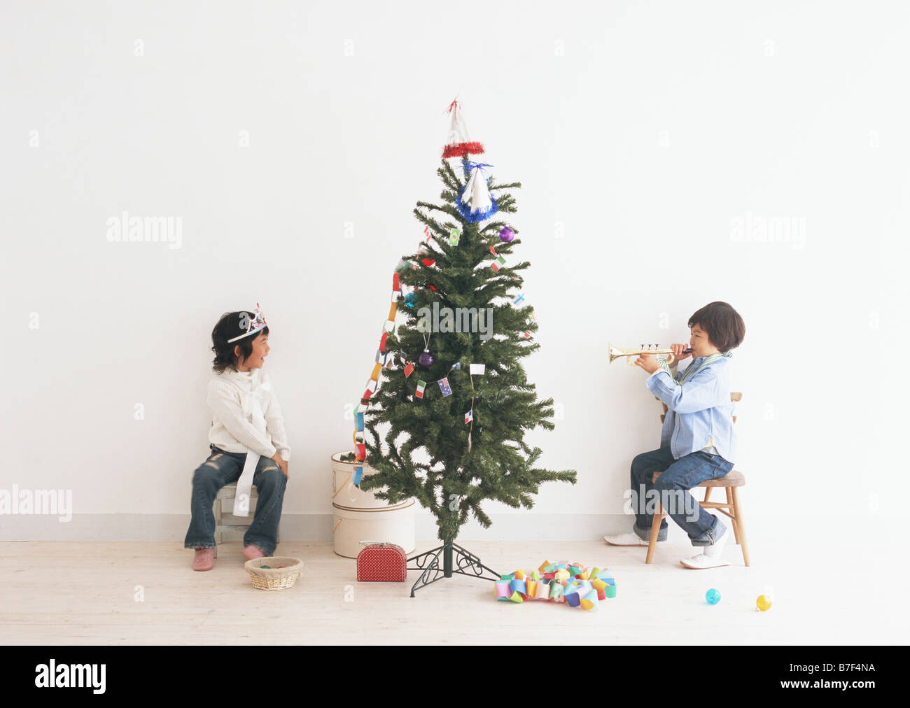 Children playing around the Christmas tree Stock Photo - Alamy