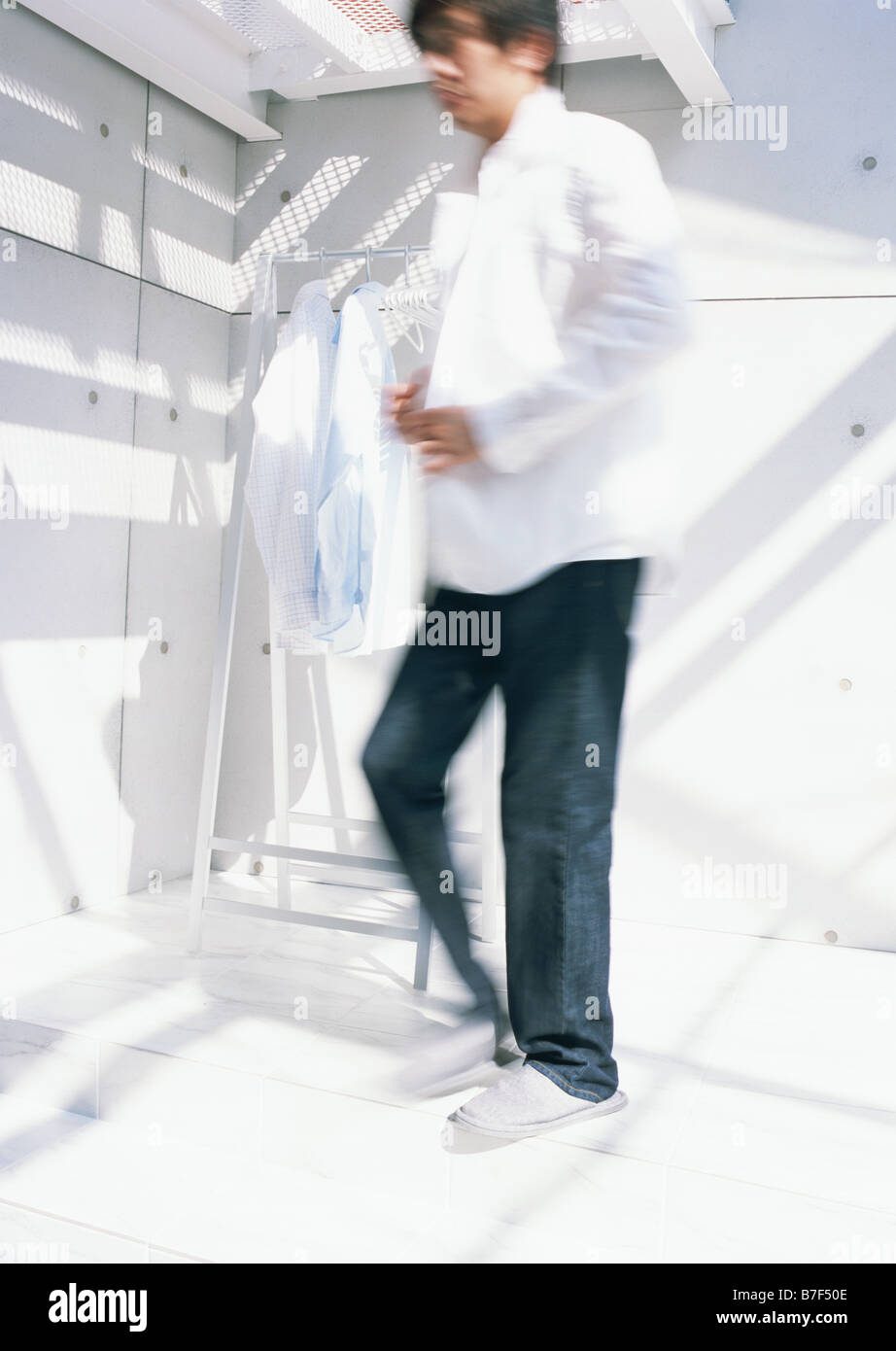 Man putting on shirt Stock Photo - Alamy