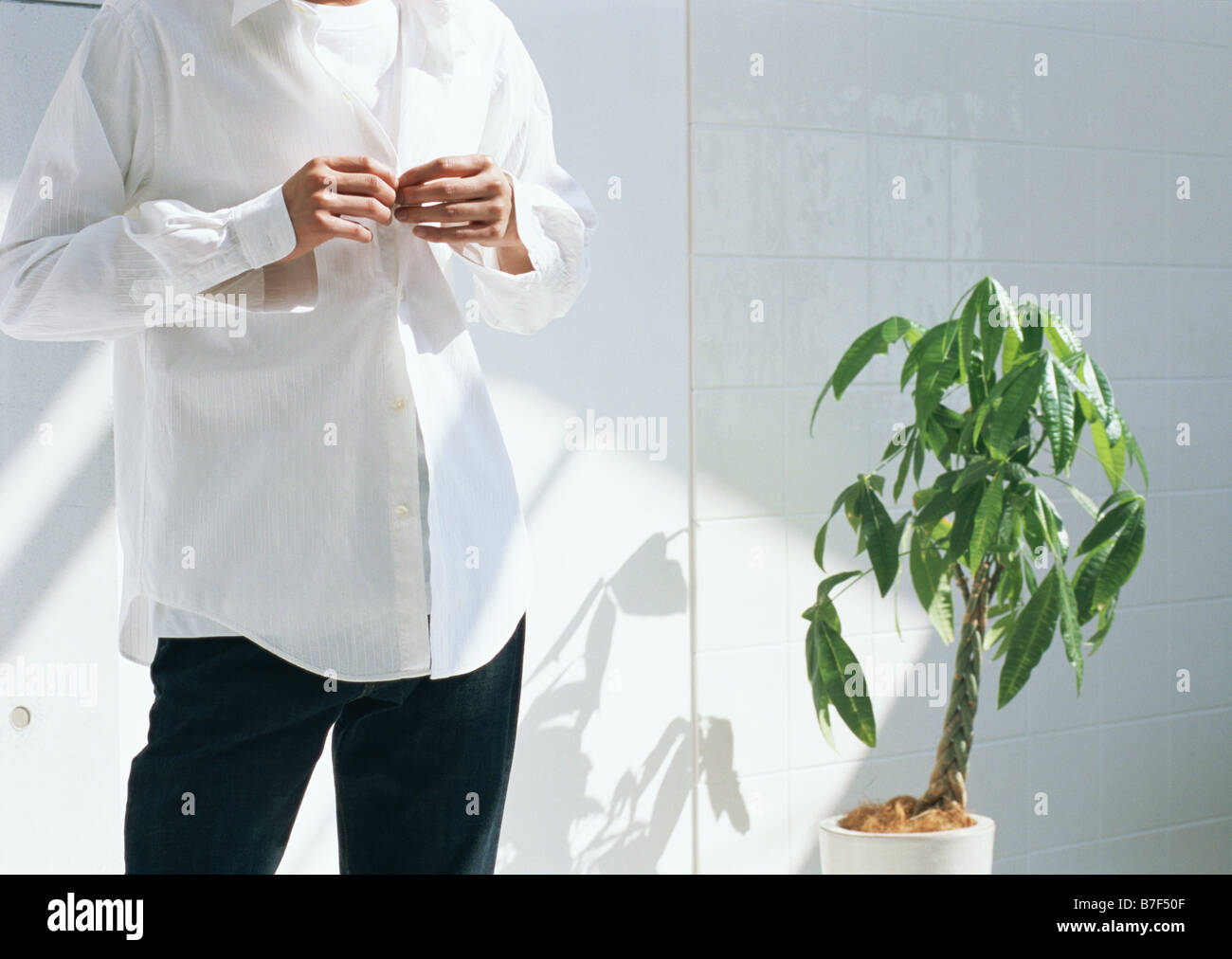 Man putting on shirt Stock Photo - Alamy