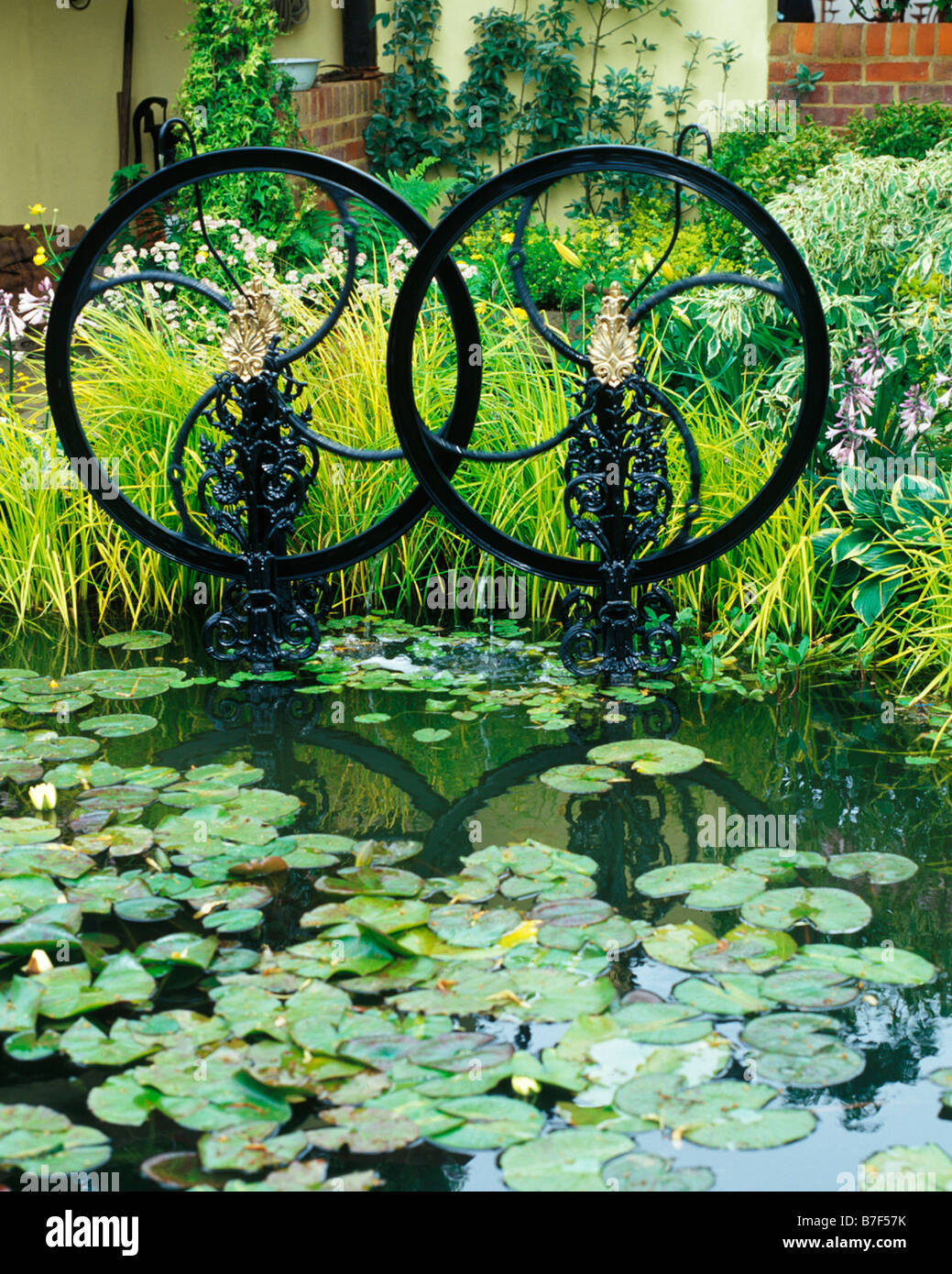 POND FEATURE WITH DECORATIVE CAST IRON WHEELS Stock Photo - Alamy
