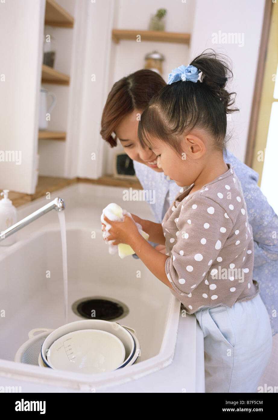 Child helping parent wash dishes hi-res stock photography and images ...