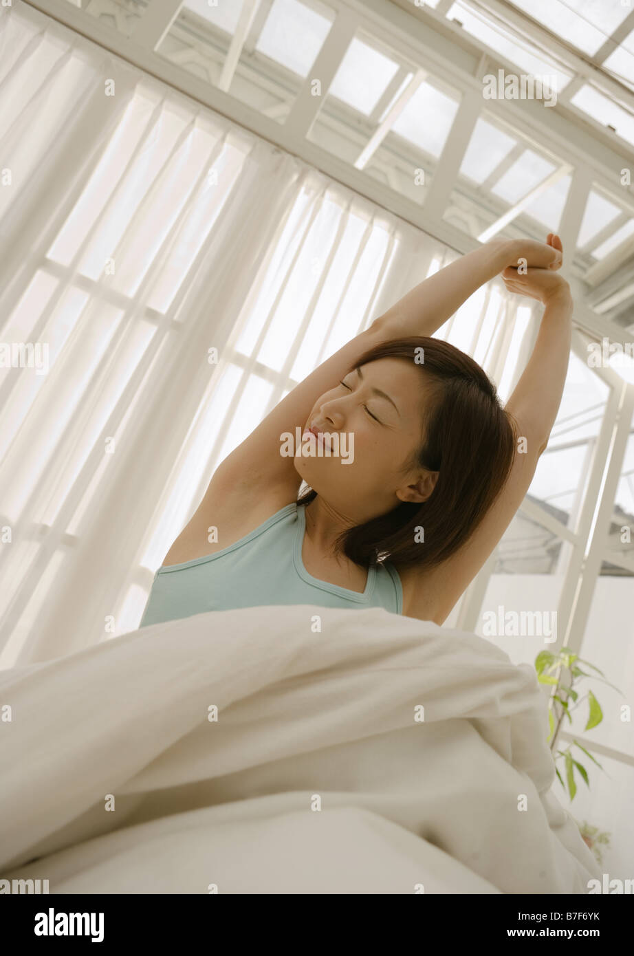 Woman stretching on bed Stock Photo - Alamy