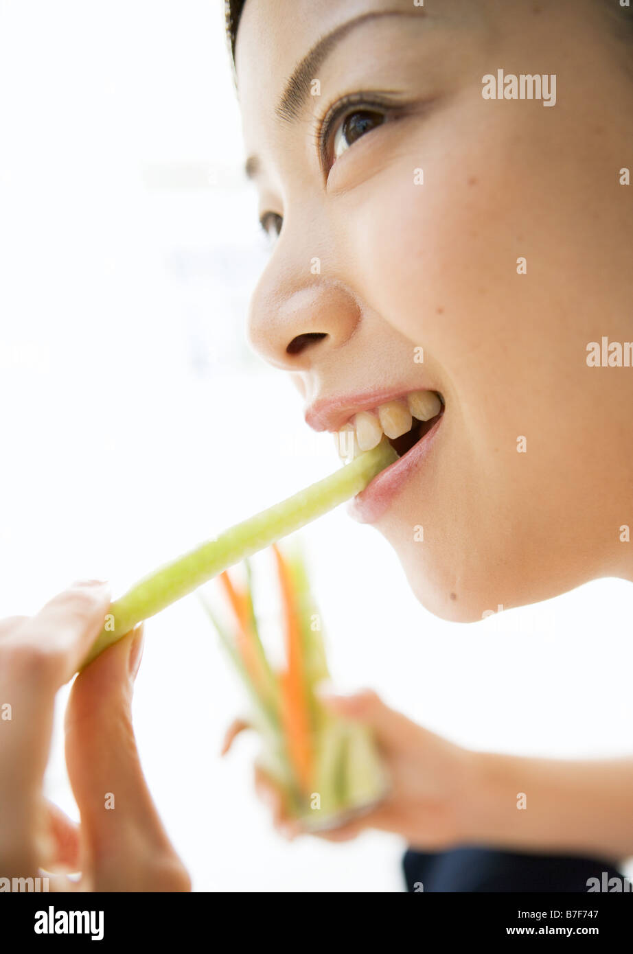 Woman eating veggie sticks Stock Photo - Alamy