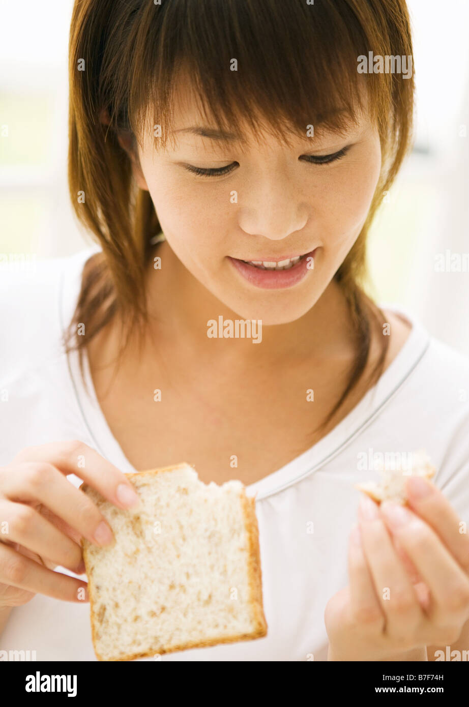 Woman eating wheat bread Stock Photo - Alamy