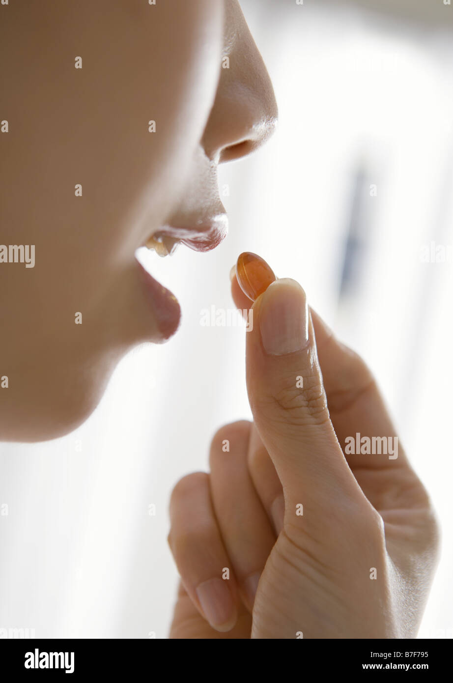Woman taking supplement Stock Photo - Alamy