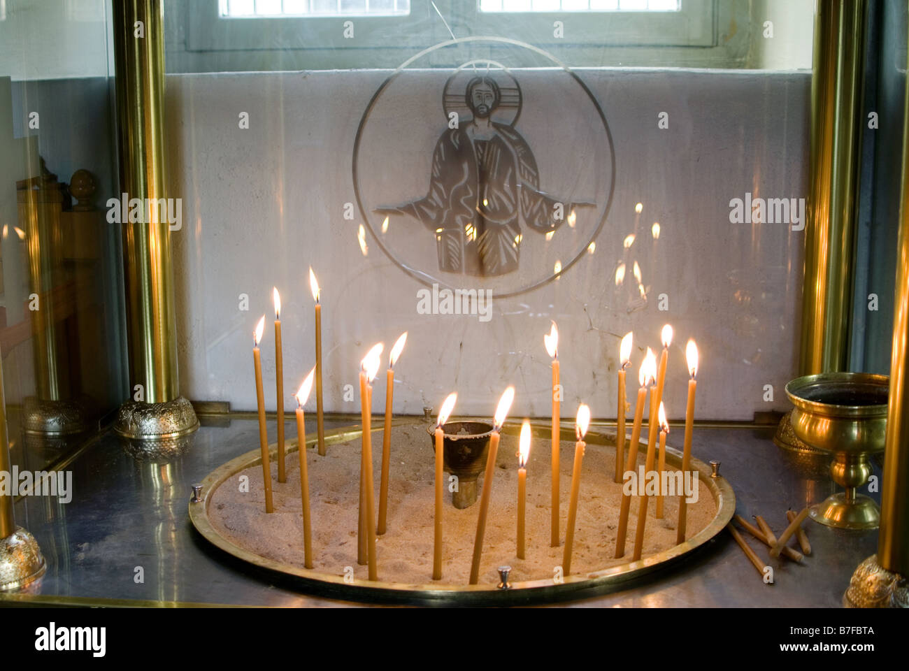 Candles in a Greek orthodox church with image of Christ Stock Photo - Alamy