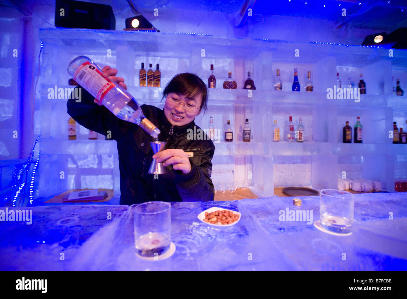 Female bartender pours a vodka in the Ice Bar in Harbin China 2009 ...