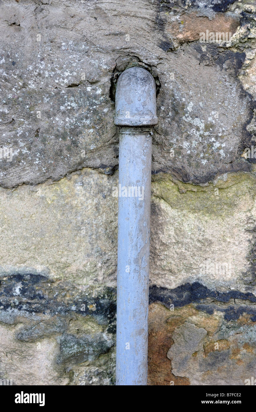 Pipe in an old stone wall Stock Photo - Alamy