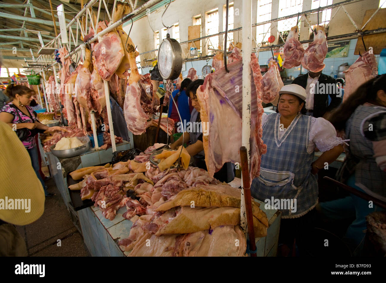 Market trader indoors selling raw meat poultry in Ecuador Horizontal ...