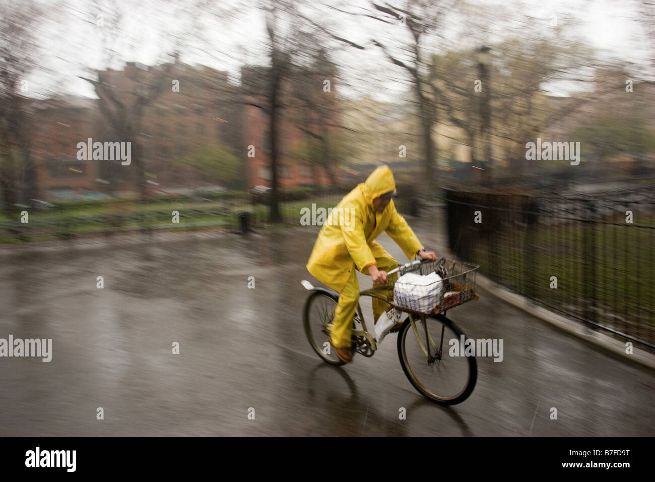 food delivery person riding a bicycle in the rain wearing a full yellow ...