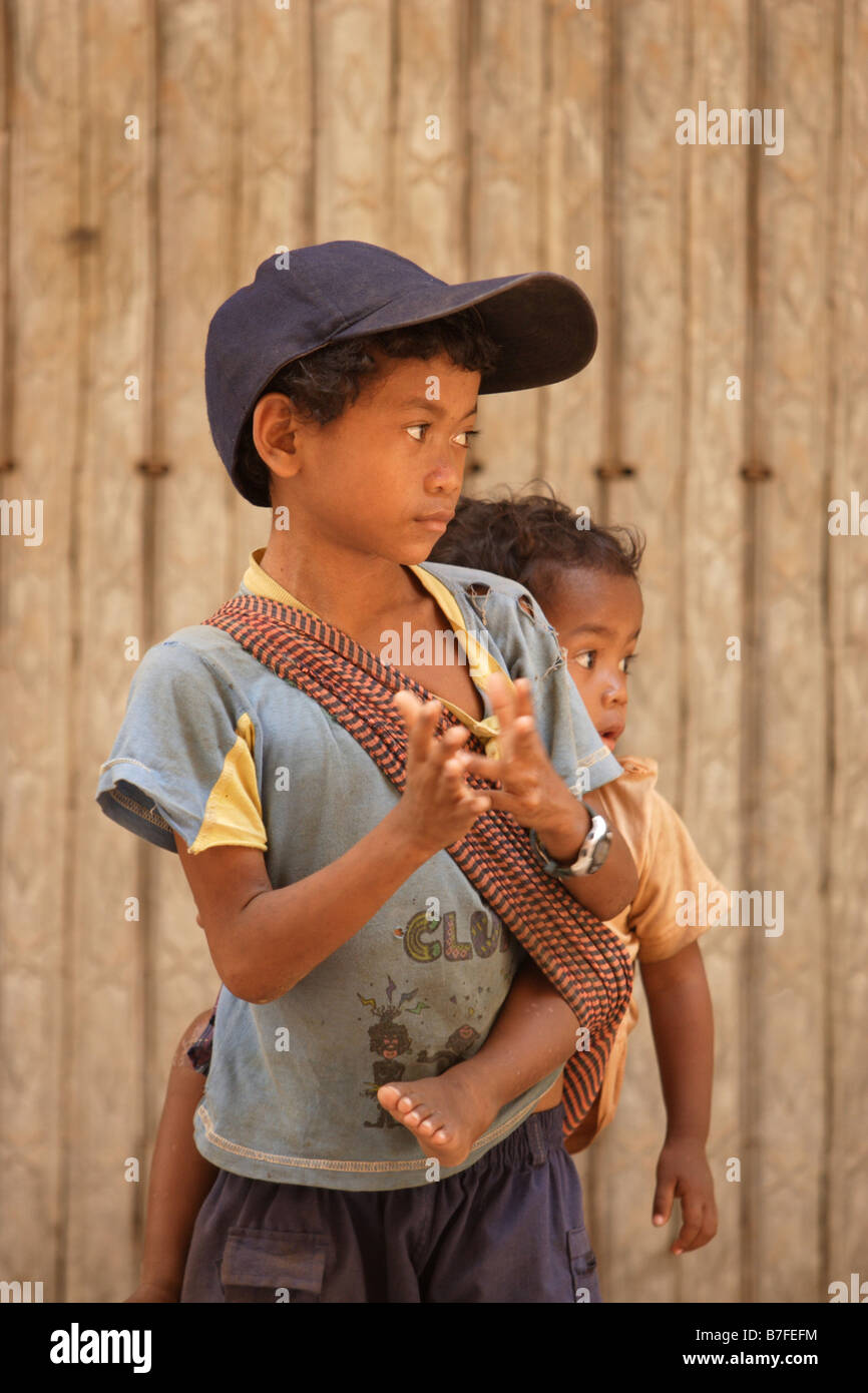 Young local street boy carrying baby sibling Stock Photo - Alamy