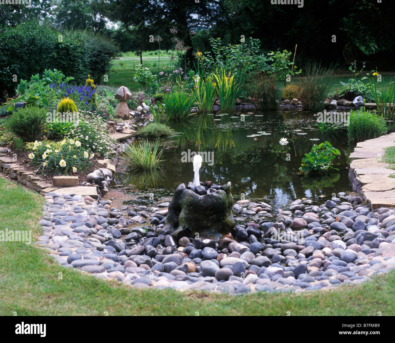 POND FOR WILDLIFE WITH SLOPINGPEBBLE AREA AND AREATION FOUNTAIN Stock ...