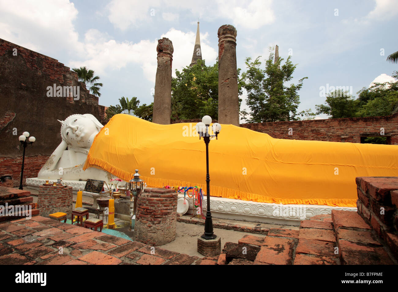 Laying Buddha with saffron robe outdoors Stock Photo - Alamy