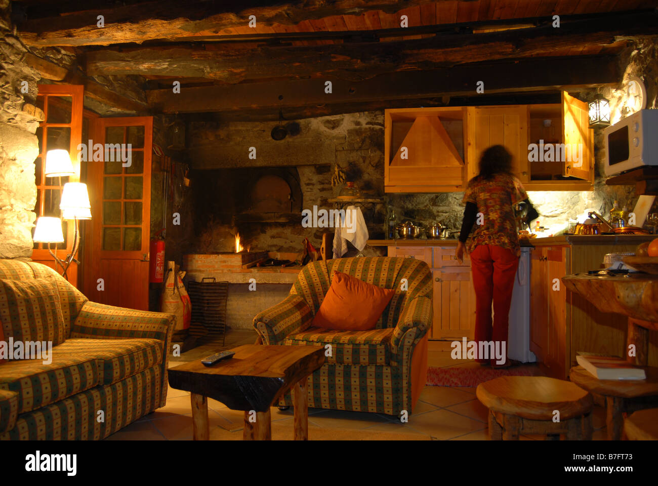 Interior rustic kitchen and living space of a rural cottage with a girl ...