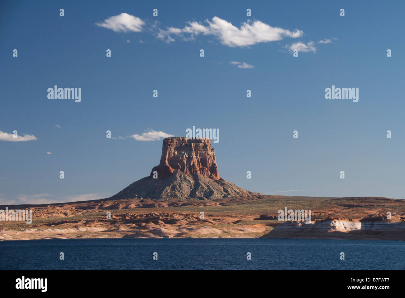 A butte on dramatic shoreline in evening light Lake Powell Utah USA ...