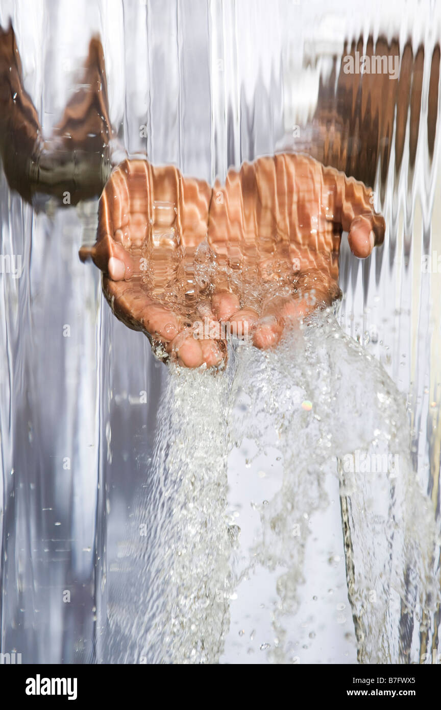 Indian boys hands poking through a cascade of water. Andhra Pradesh ...