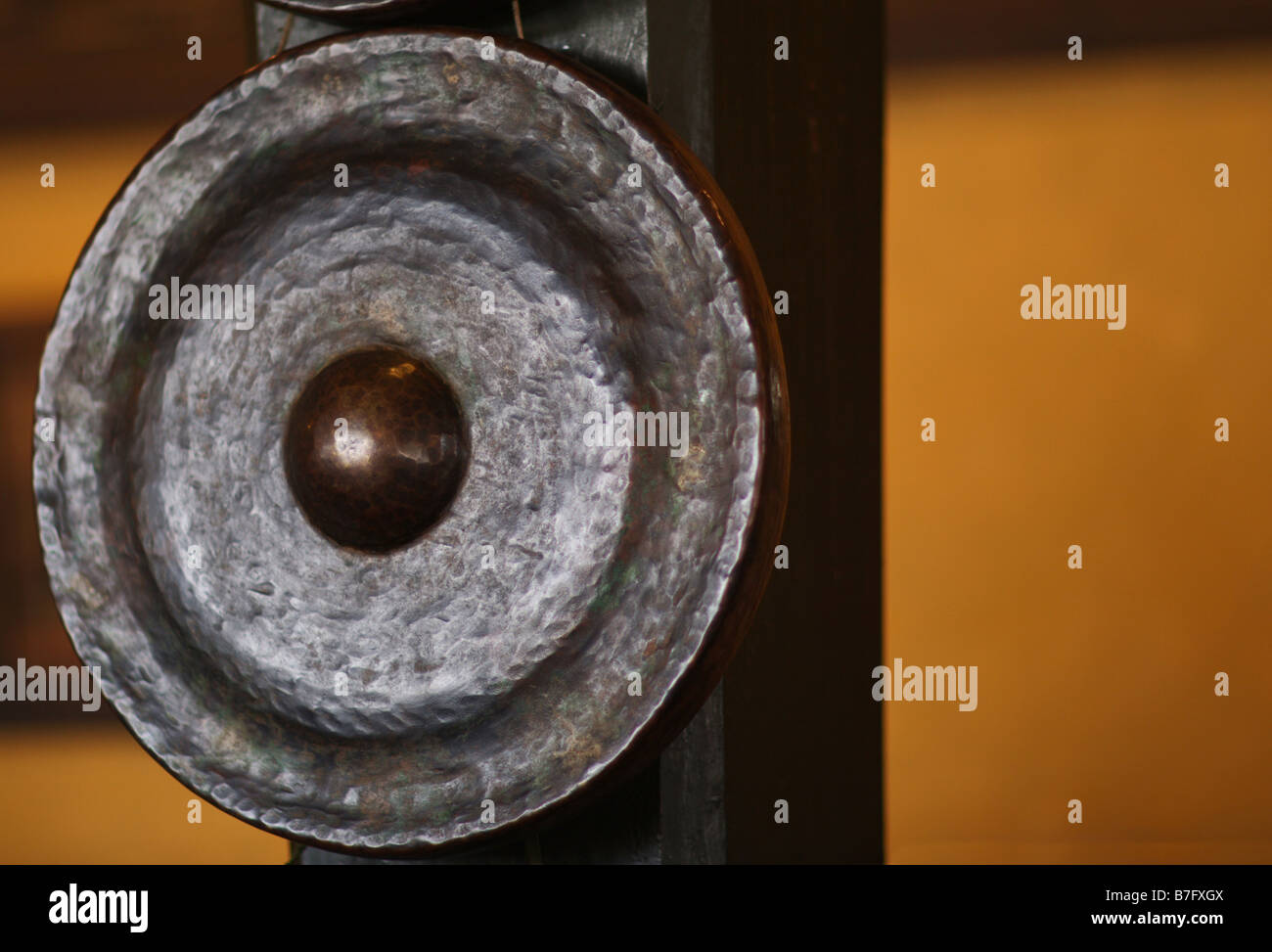 Metal gong hanging on wooden post Stock Photo - Alamy