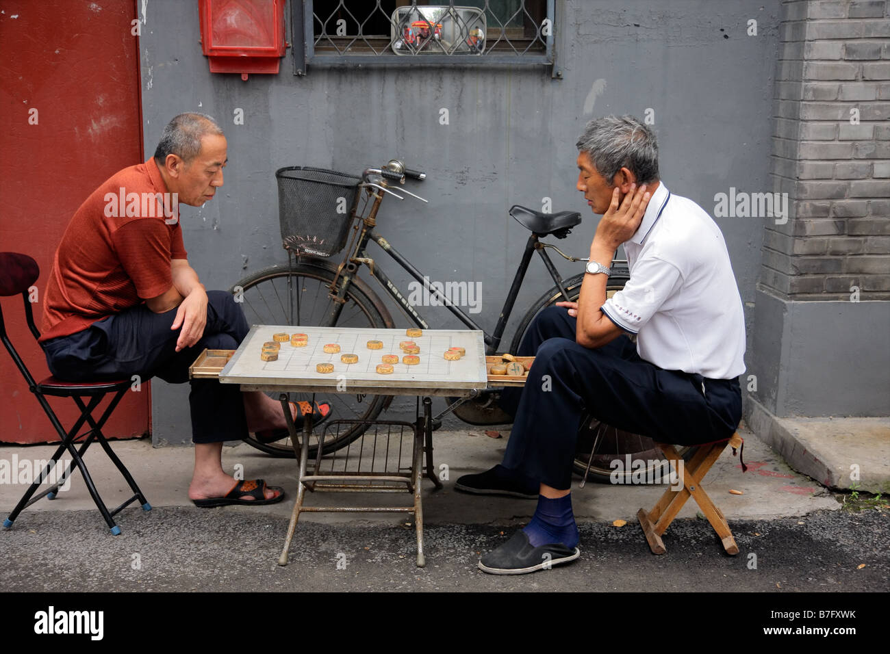 Two Chinese men playing a board game in a narrow alley of the Hutong, Beijing, China Stock Photo ...