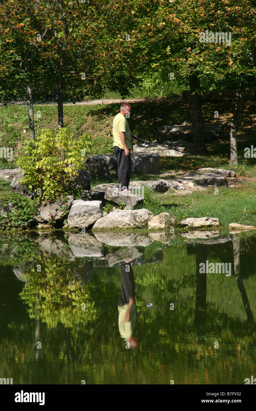 Man and reflection by a lake Stock Photo - Alamy