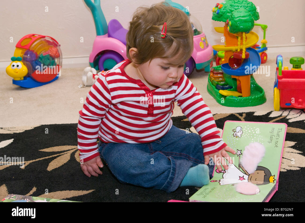 Baby Girl Child Looking at and Reading a Book Stock Photo - Alamy