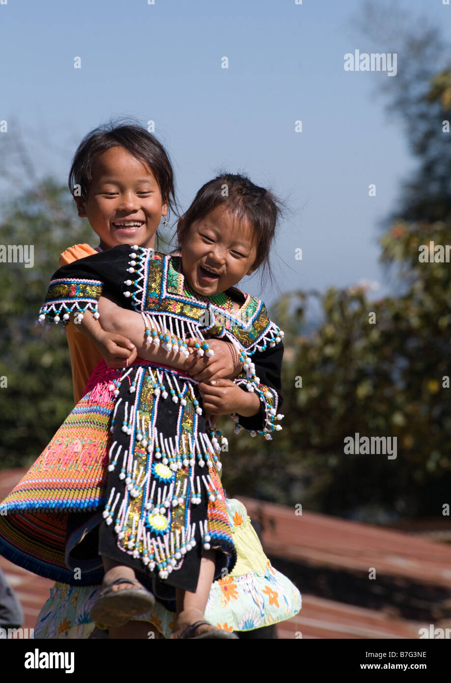 Two young Hmong girls play at a Hmong New Year ceremony. The younger ...