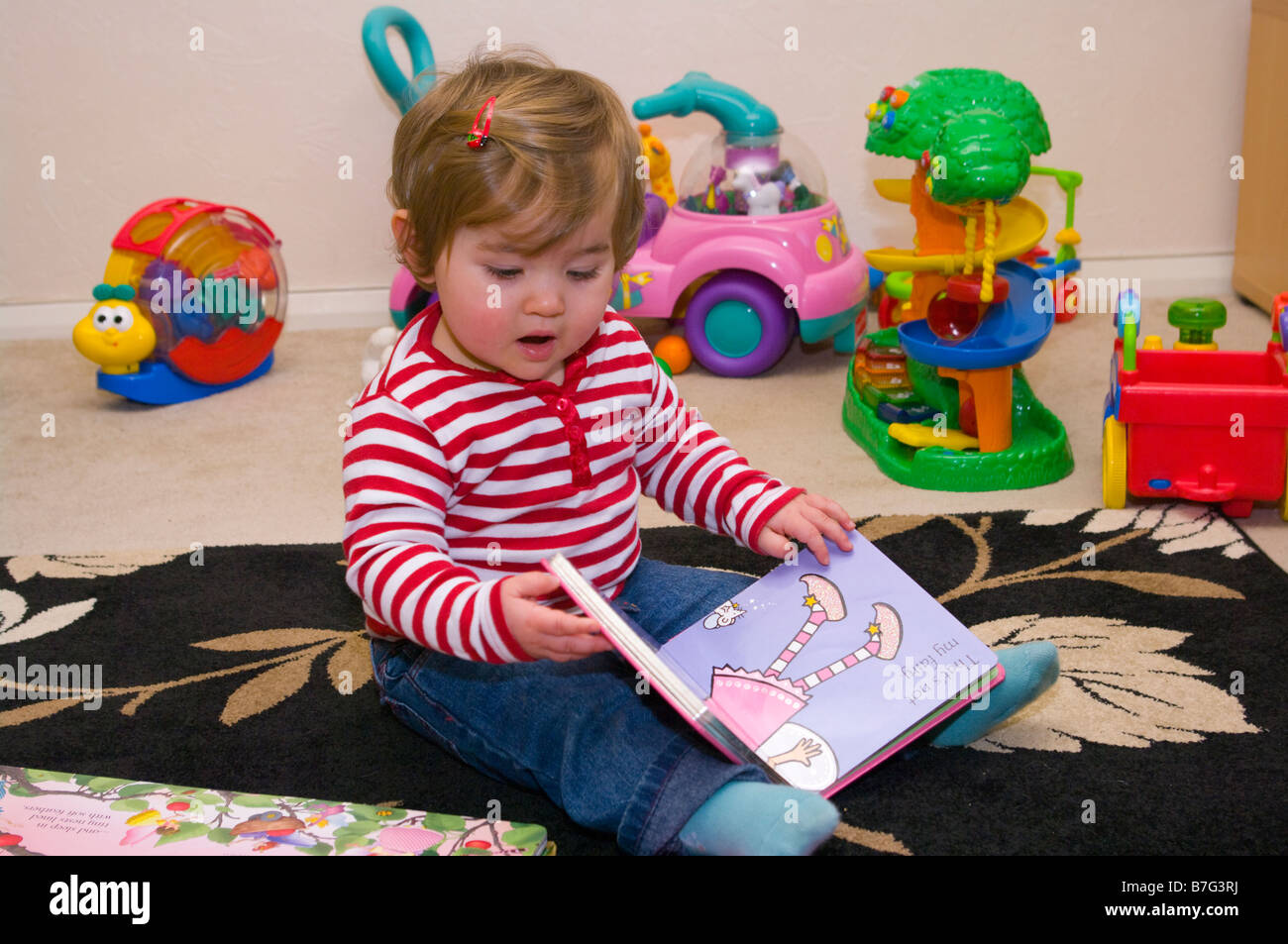 Baby Girl Child Looking at and Reading a Book Stock Photo - Alamy