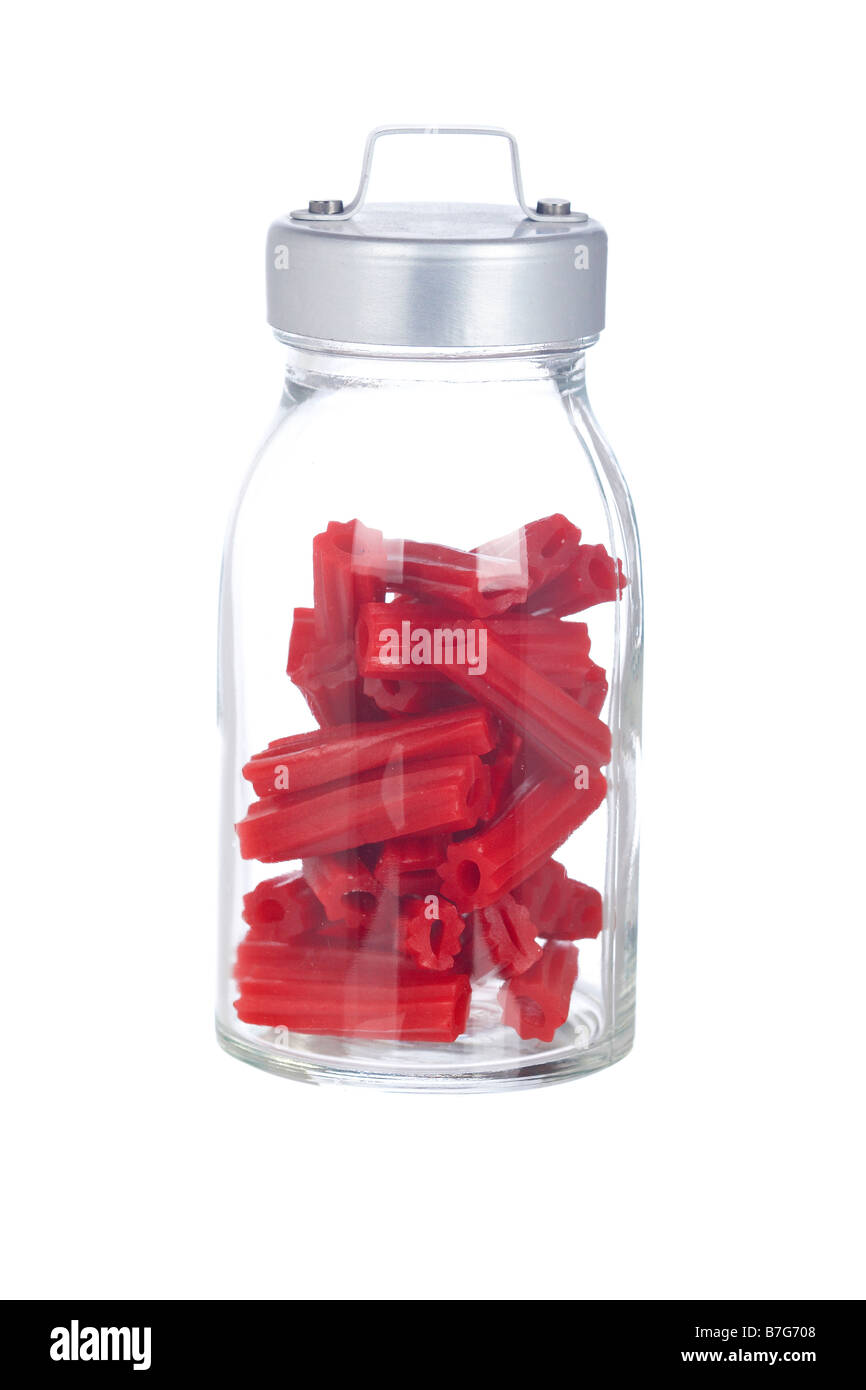 Pieces of red licorice on glass jar isolated on white background Stock ...