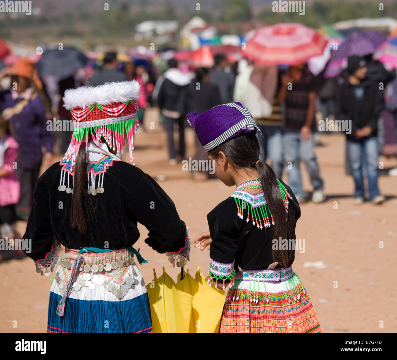 A view from behind of two Hmong girls in traditional costume walking ...