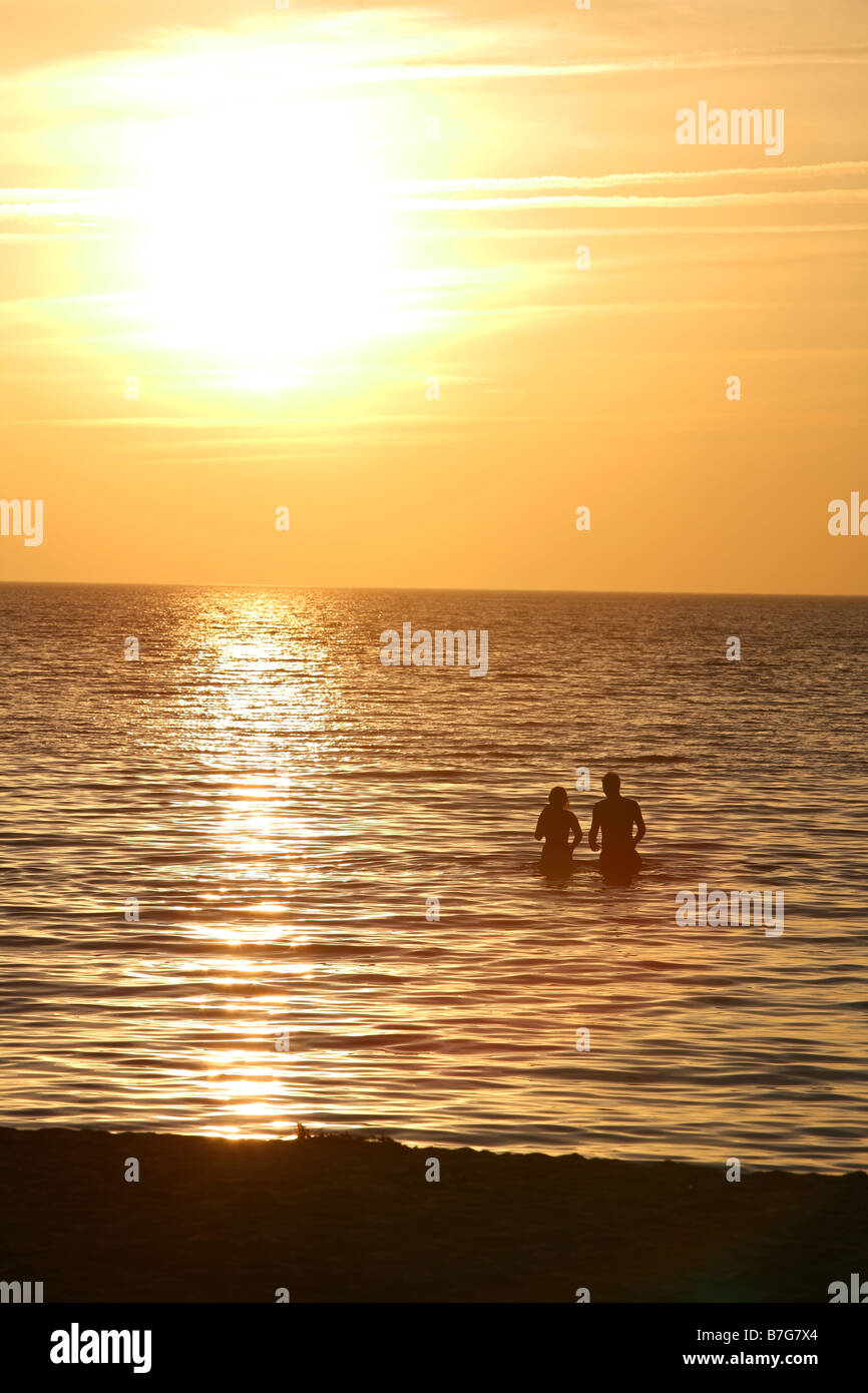 swimmers at sunset Stock Photo - Alamy
