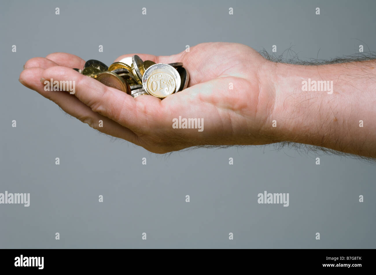 A mans hand offering a handful of euro coins Stock Photo - Alamy