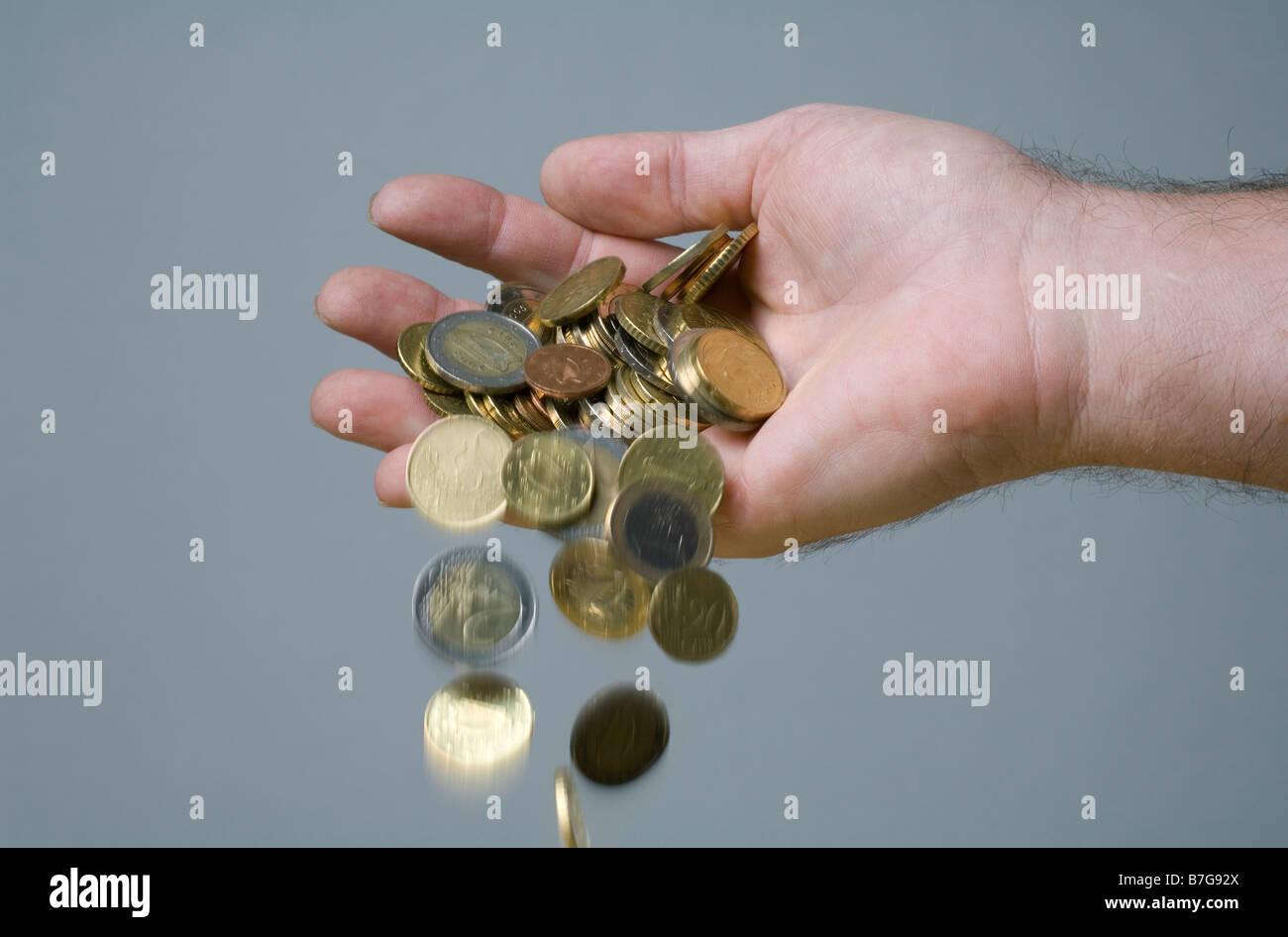 Euro coins falling from a mans hand. Money being thrown away. Money ...