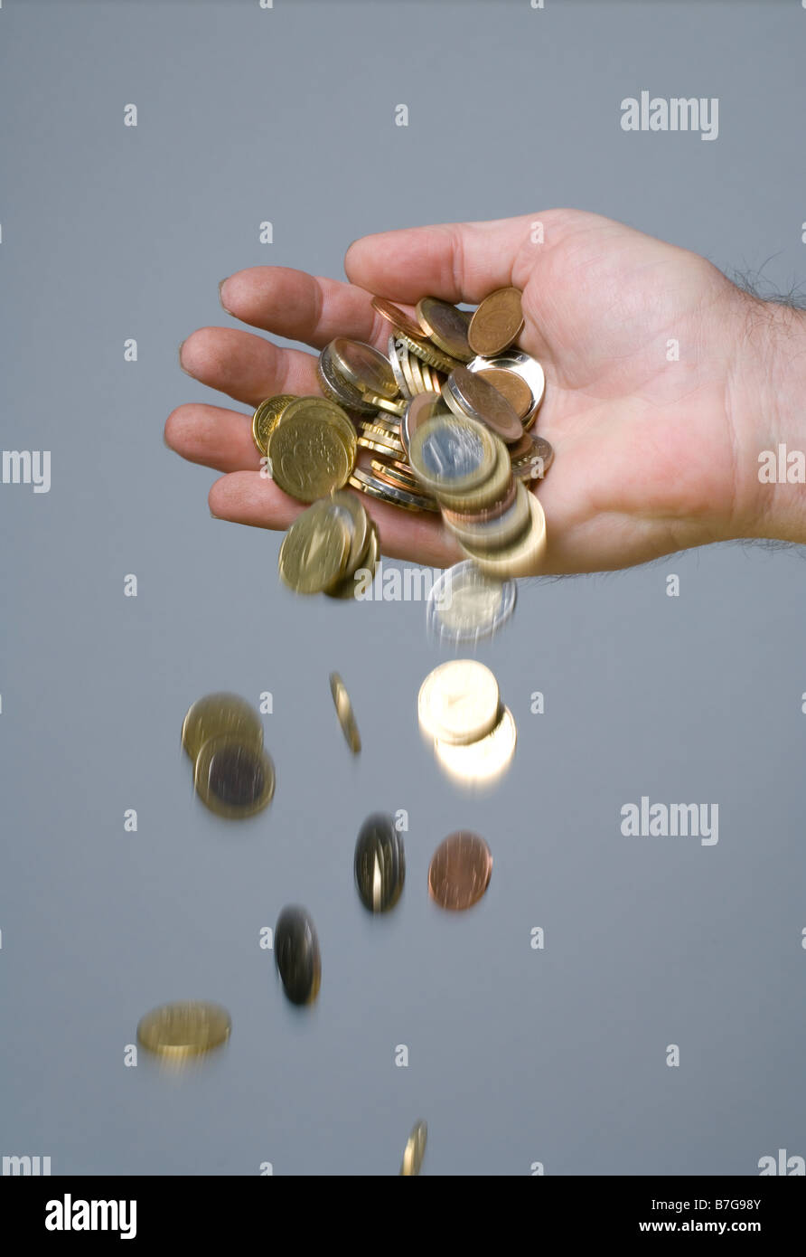 Euro coins falling from a mans hand. Money being thrown away. Money ...