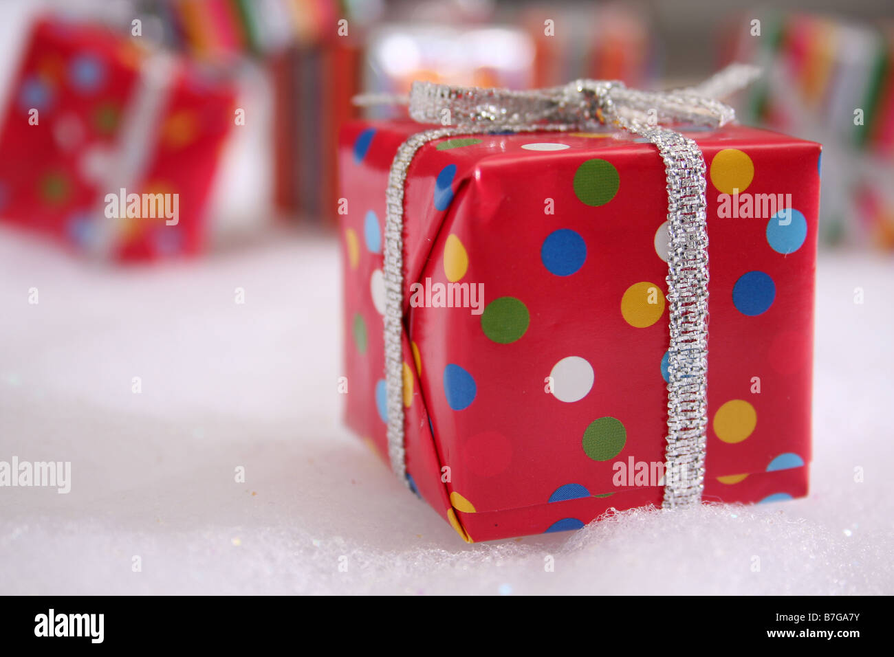 This is a studio shot of Christmas parcels in shiny red wrapping paper ...