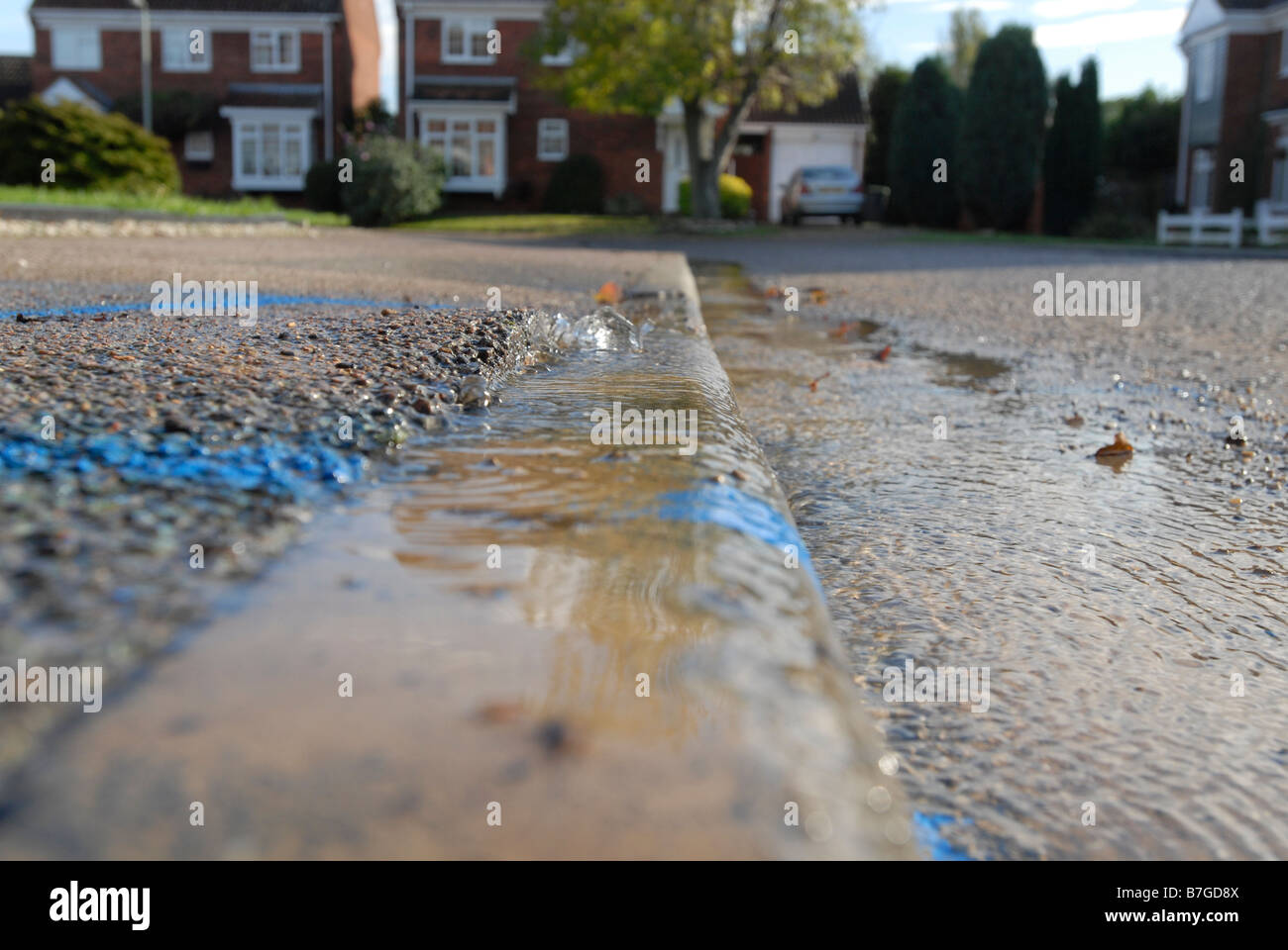 Water leaks from a pavement in a residential road Stock Photo - Alamy