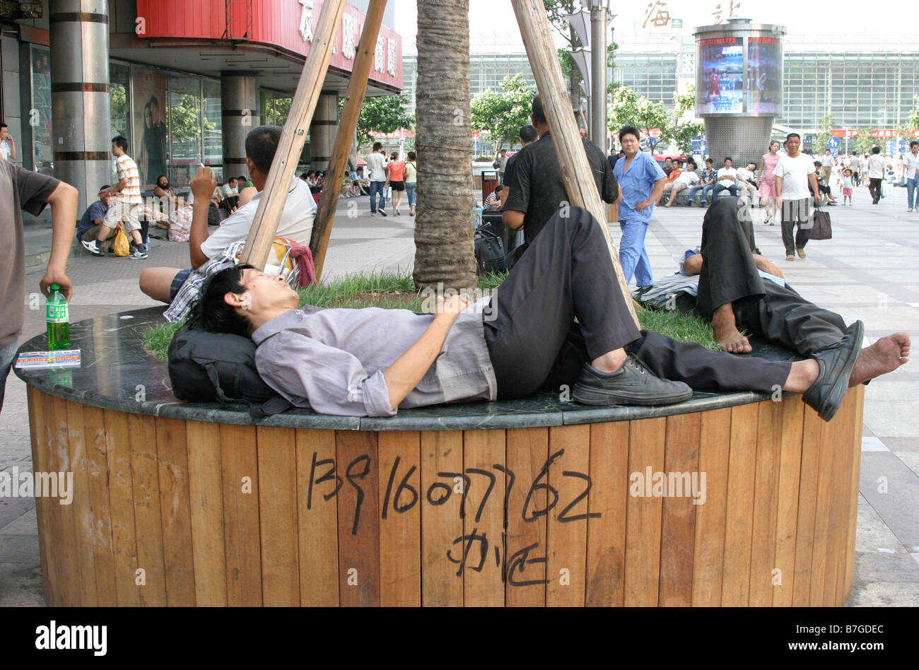 Sleeping Chinese on a street of Shanghai. People take a nap anywhere ...