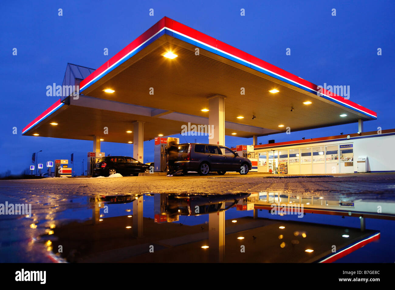 petrol station reflecting in a puddle in dusk, Germany Stock Photo - Alamy