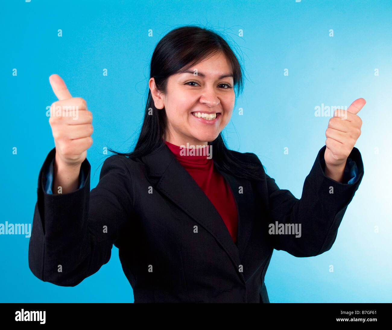 A happy young woman displaying extreme approval with a thumbs up ...