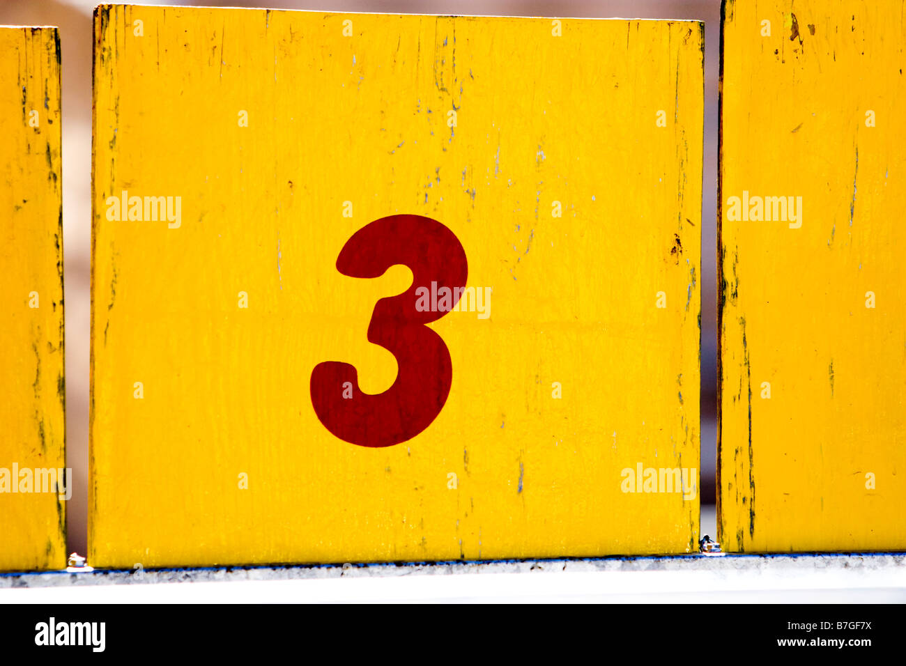 Painted red number 3 on yellow wood Stock Photo - Alamy