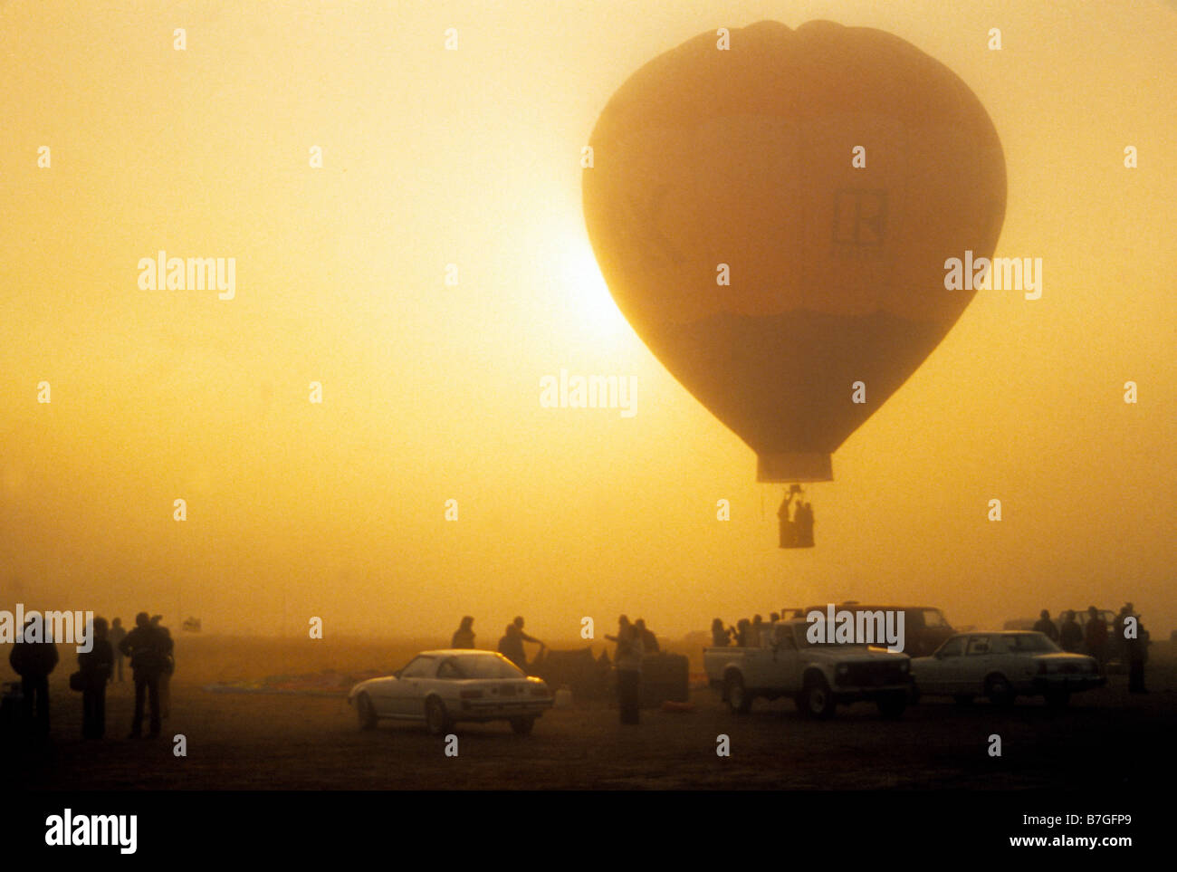 Hot air balloon rises into sky against rising sun, Perris, California ...